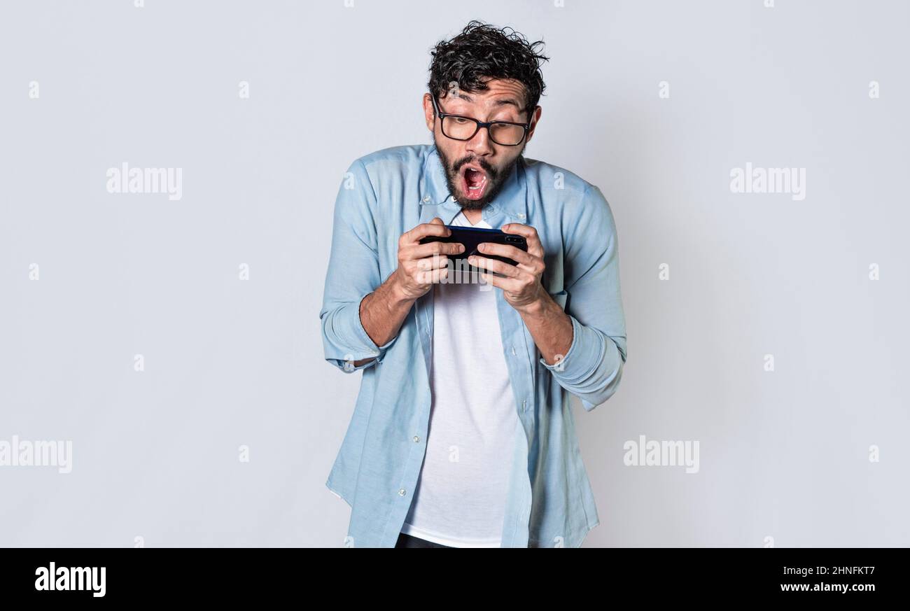 Man holding cell phone horizontally, Guy gasping and playing games on ...