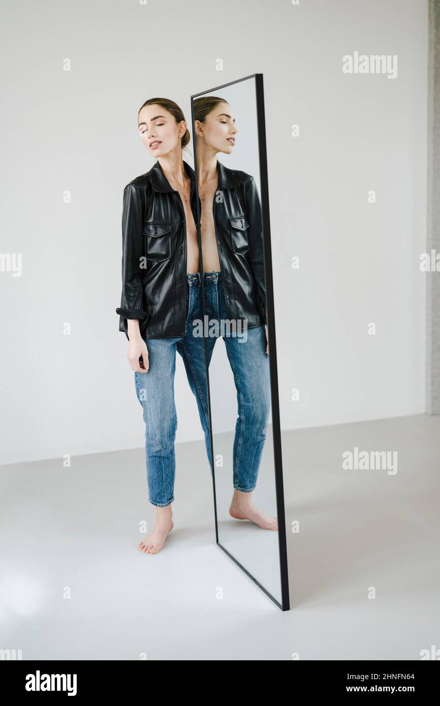 Attractive Young Woman Reflected in Body-Size Mirror Stock Photo - Alamy