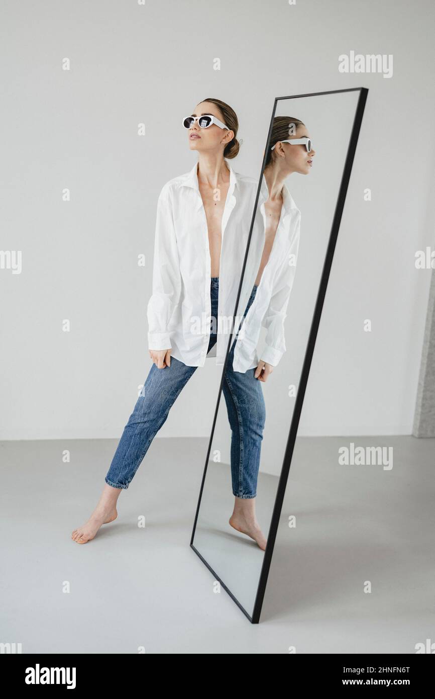 Attractive Young Woman Reflected in Body-Size Mirror Stock Photo - Alamy