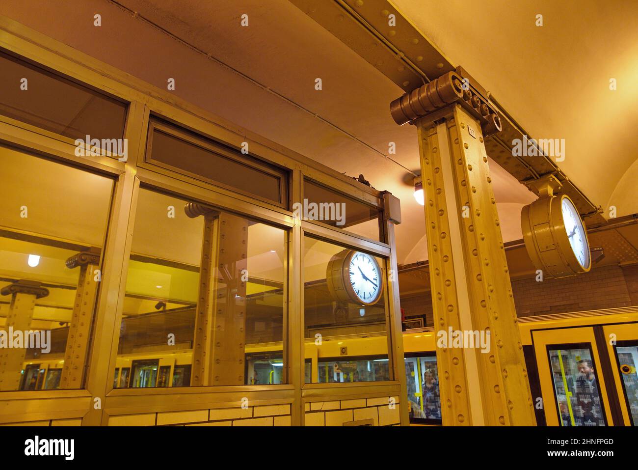 Clock reflected in a pane and steel girders of the underground station ...
