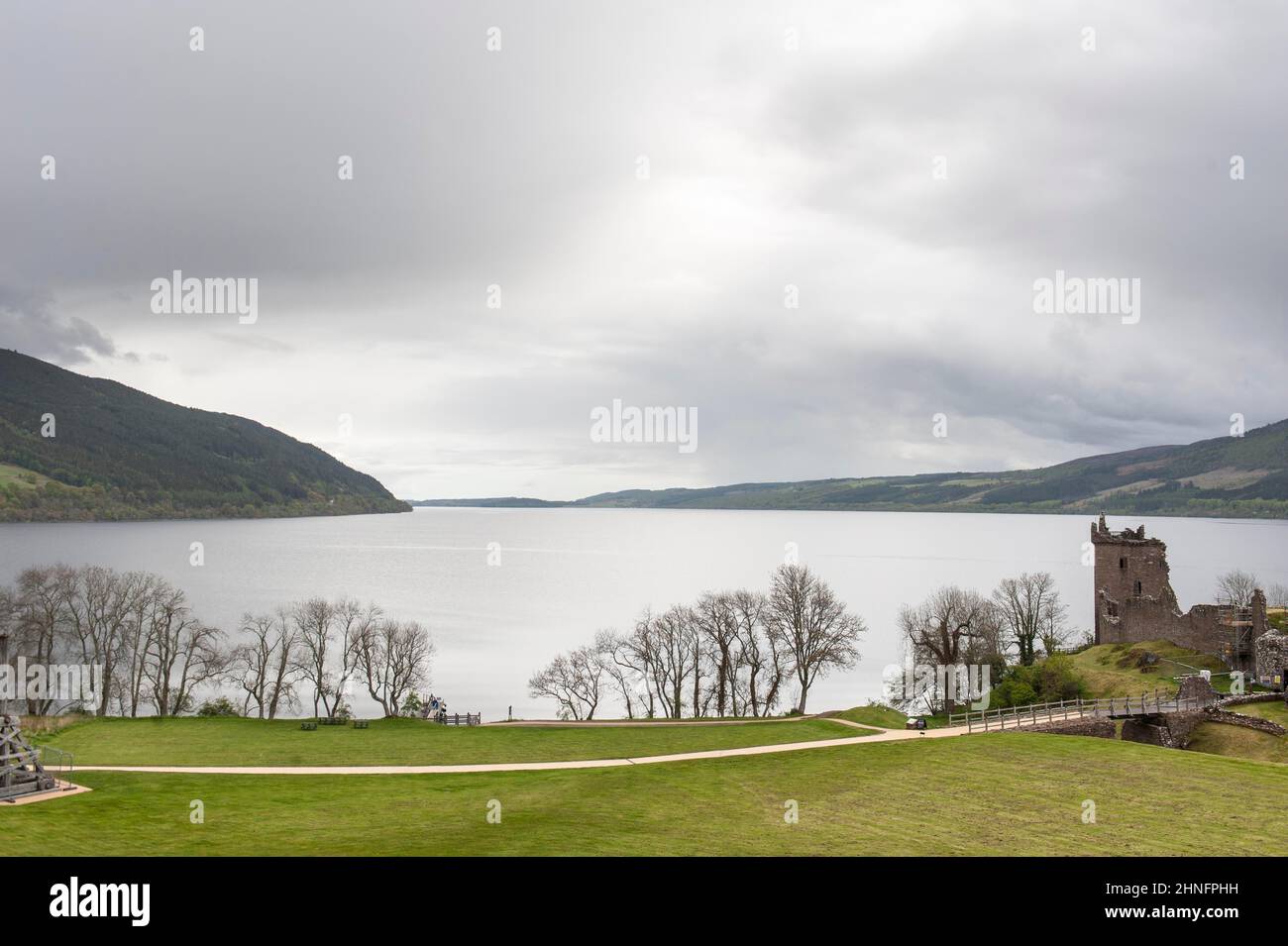 Castle ruin with tower, tree silhouettes, grey overcast sky, Urquhart ...