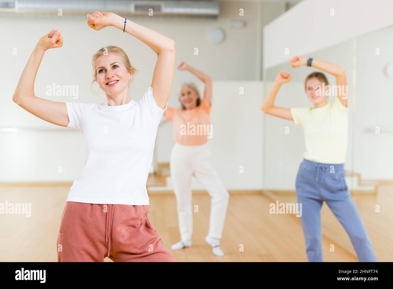 Woman performing aerobic dance during group training Stock Photo - Alamy