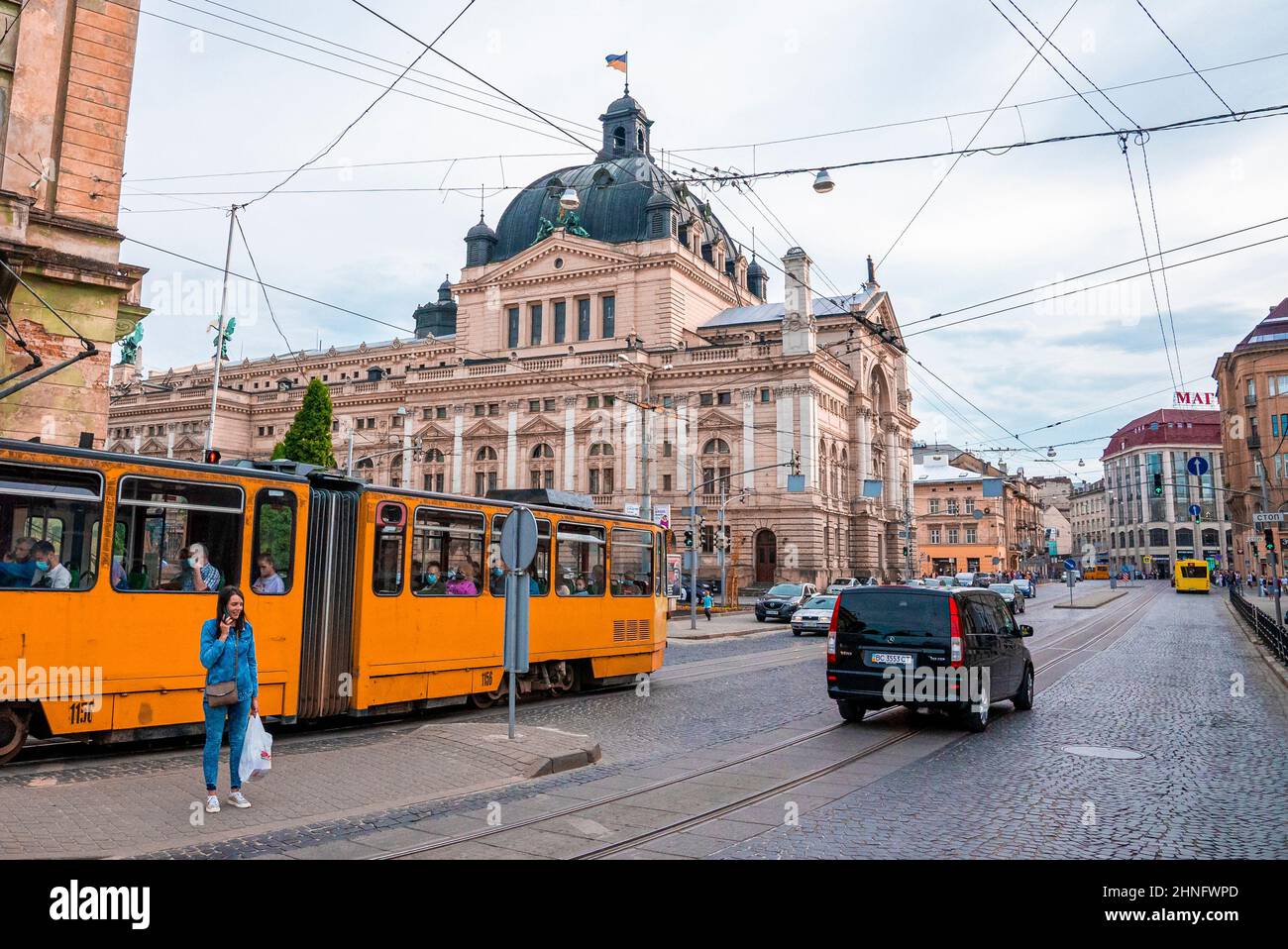 Tram along with vehicle on city streets against opera house Stock Photo ...