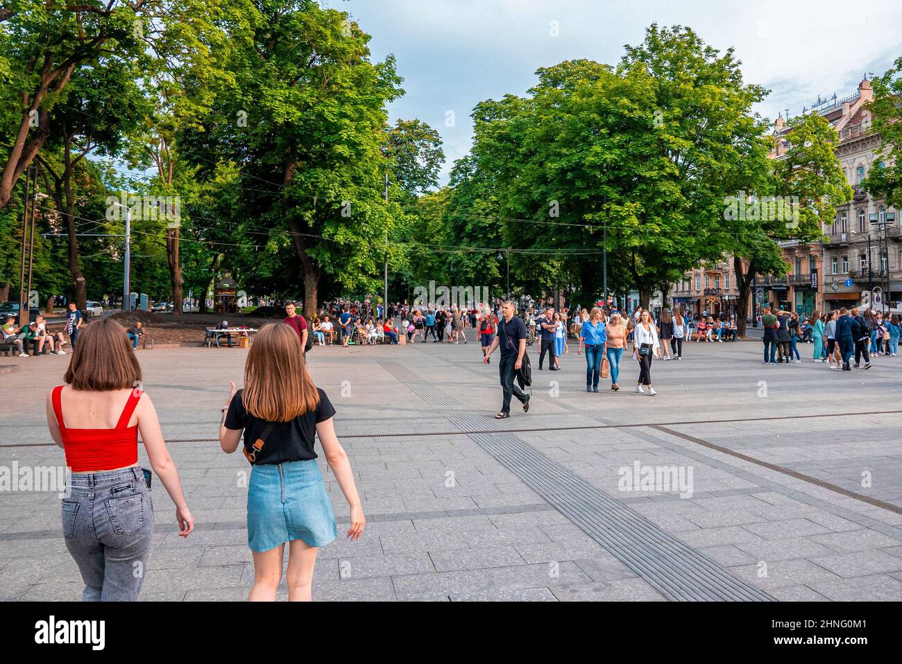 Large crowd of people on paved street against park and building Stock ...