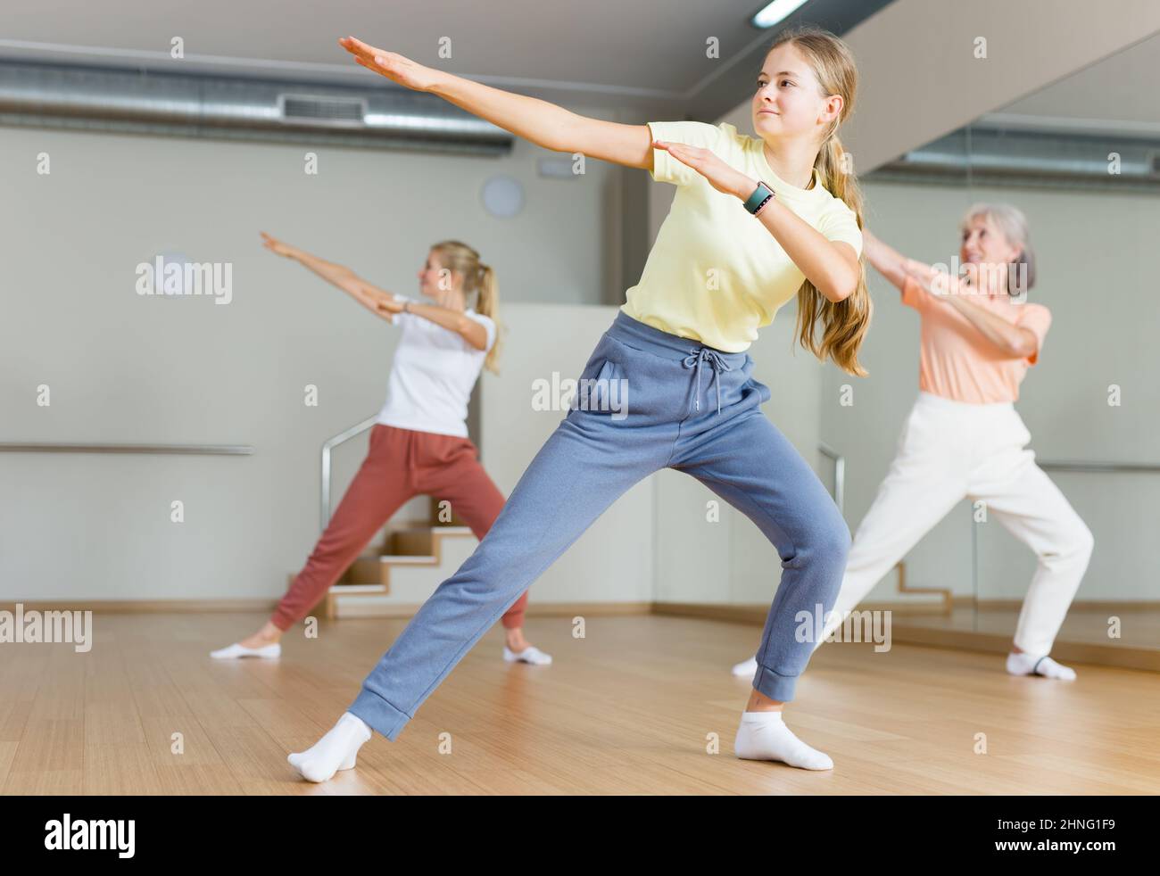 Happy teen girl with family training movements of dance in choreography ...