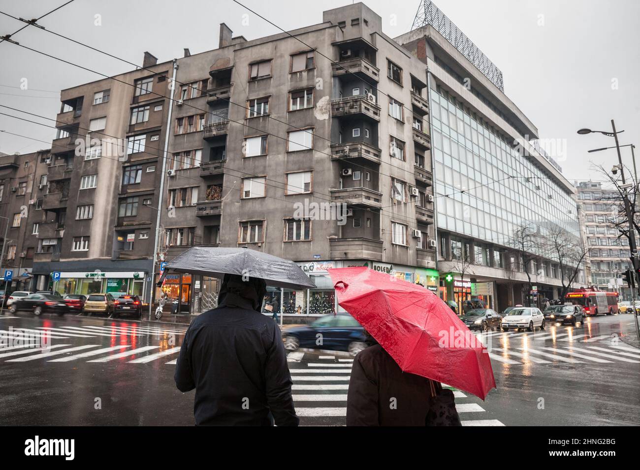Picture of people with an umbrella waiting for green light to cross a ...