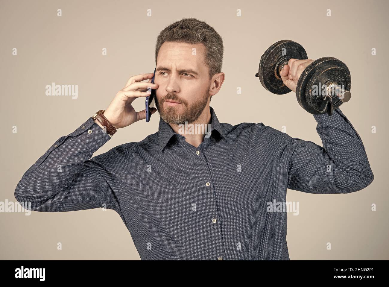 strong bearded man businessman training with barbell and speaking on ...