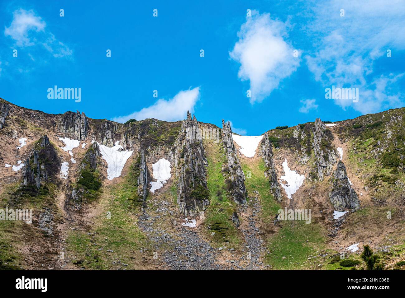 Low angle view of rock cliff covered with moss and snow and sky Stock ...