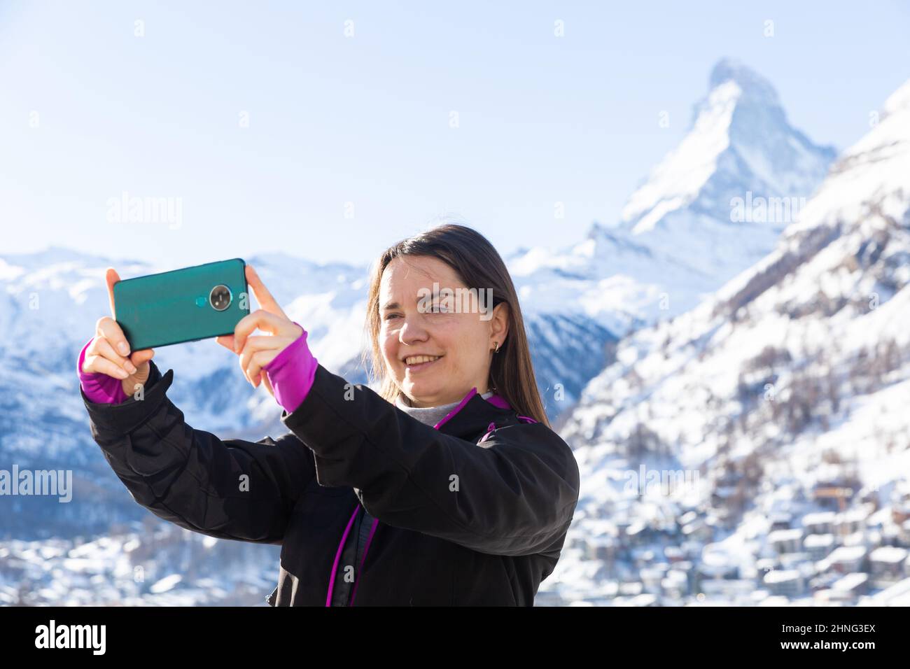 Happy traveler woman recording video of mountain views on mobile phone ...