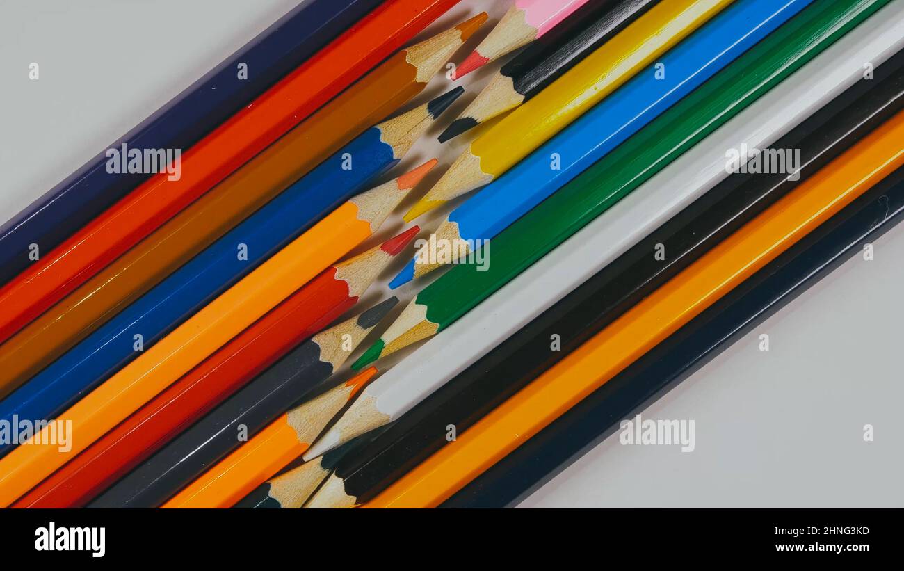 Many colored pencils are arranged around the edges of the image as a ...