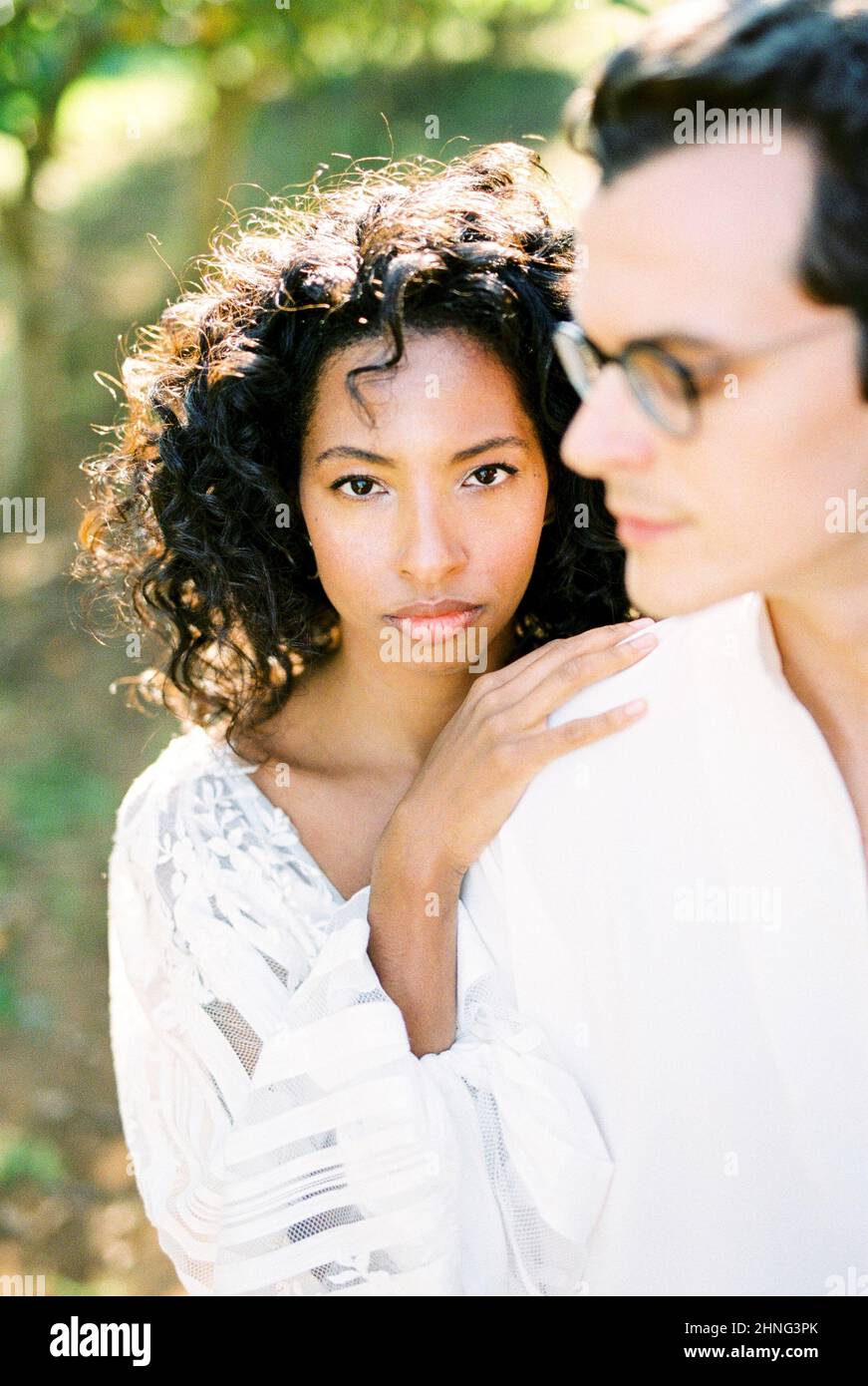 Woman hugs a man by the shoulders from behind. Portrait Stock Photo - Alamy
