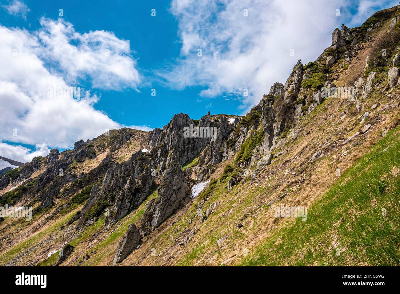 Rock cliff covered with moss over steep slope against cloudy sky Stock ...
