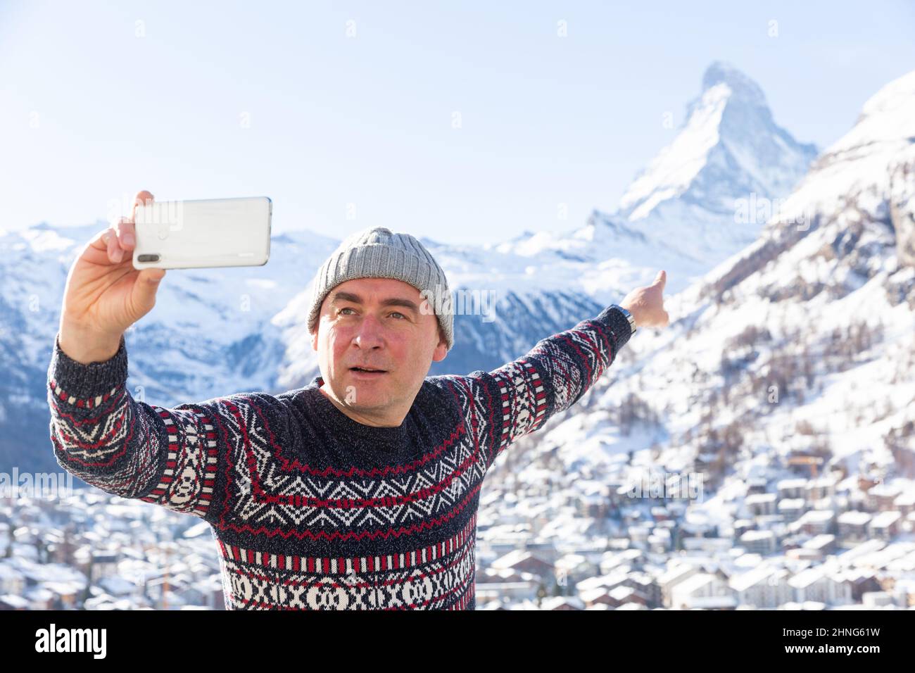 Travel blogger pointing at Matterhorn recording vlog with smartphone ...