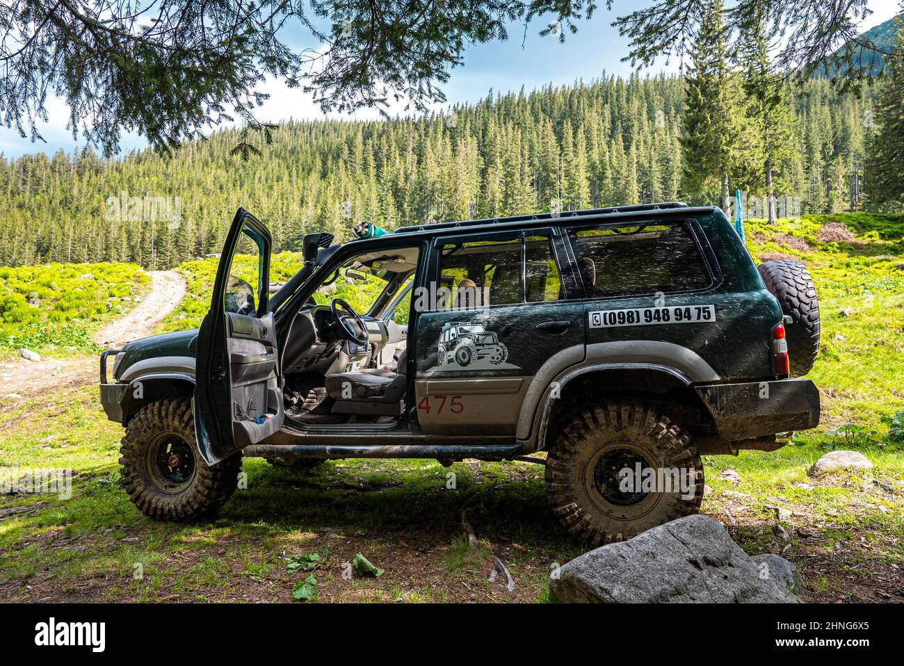 Off road 4x4 suv with open door under tree against dense forest Stock ...