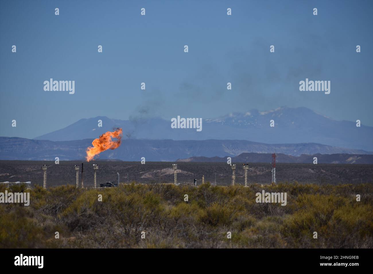 View of natural gas flare at an oil and gas filed against mountains and ...