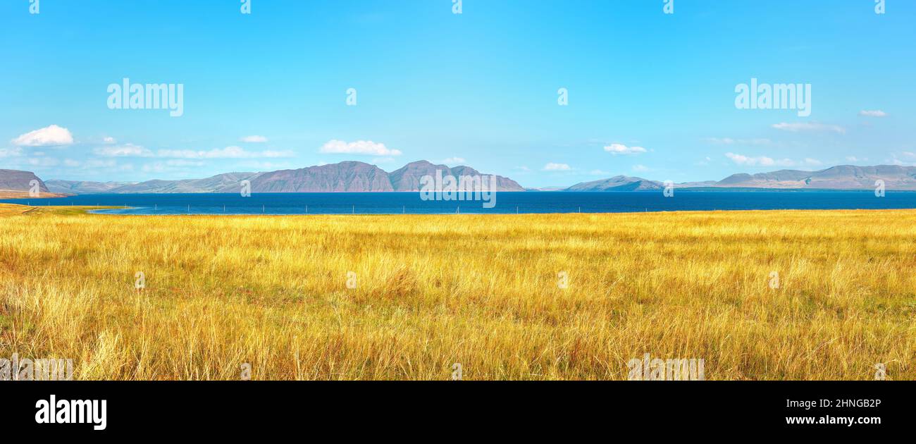 Steppe plain on the background of Mount Tepsey under a blue cloudy sky. Siberia, Russia Stock ...