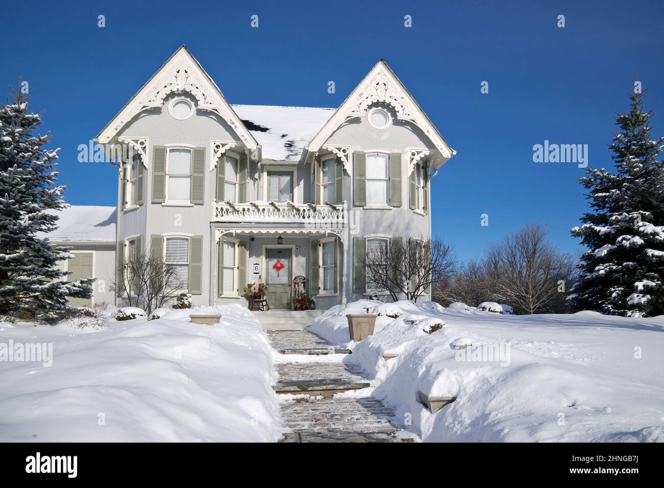Winter landscape of Victorian-style house exterior with deep snow in ...