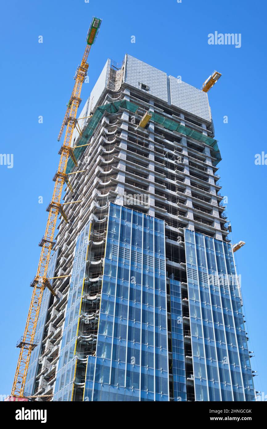 Tall, modern, glass office towers under construciton. At the downtown ...