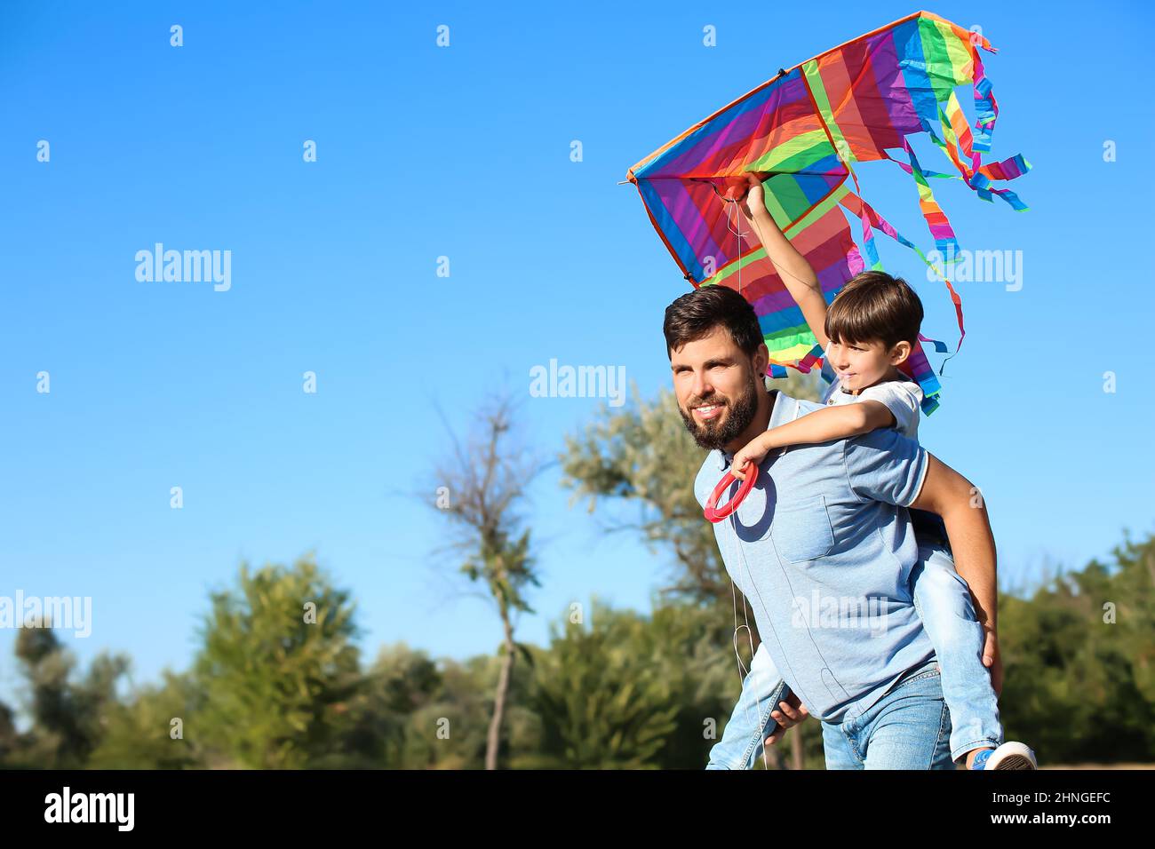 Happy father carrying pickaback his little son with kite in park Stock ...