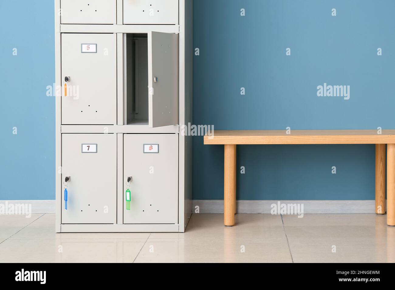 Modern locker and bench near blue wall Stock Photo - Alamy