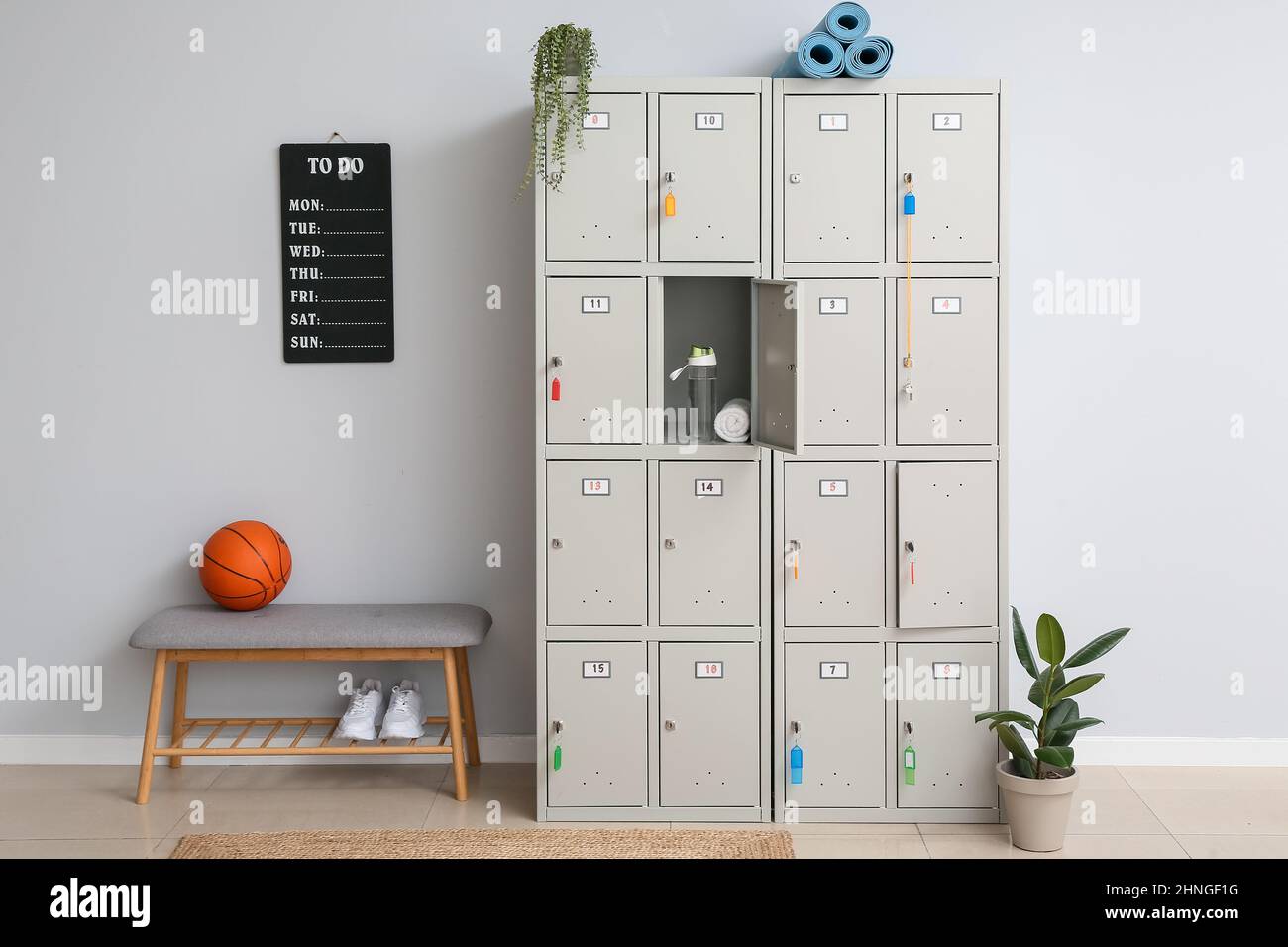 Locker with sport equipment and bench in change-room Stock Photo - Alamy