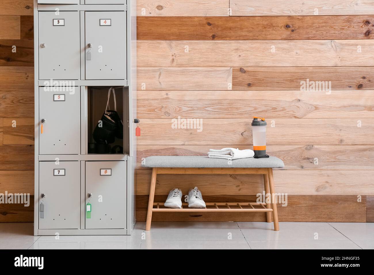 Locker with sport equipment and bench in change-room Stock Photo - Alamy