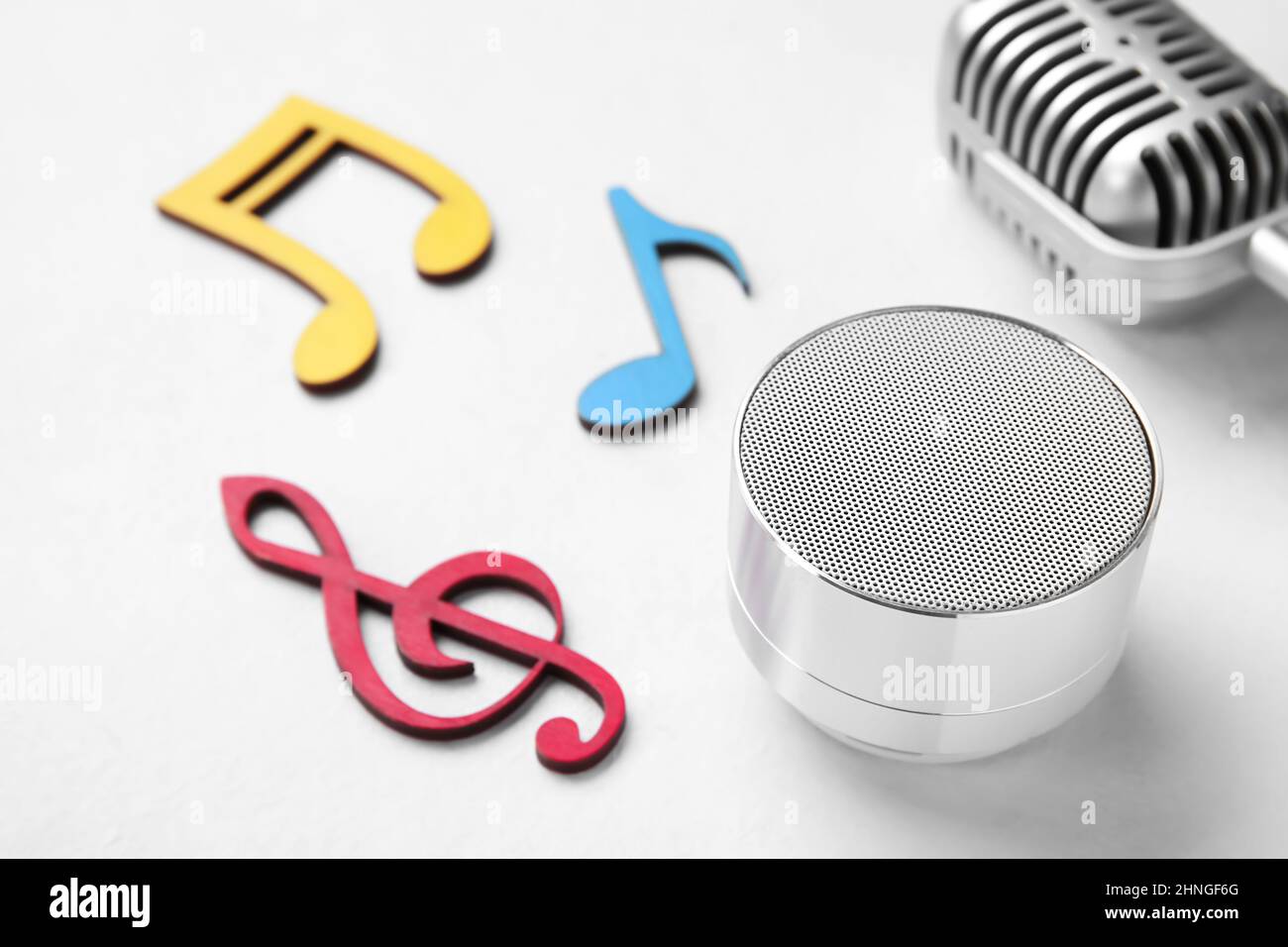 Wireless portable speaker, microphone and music notes on light ...