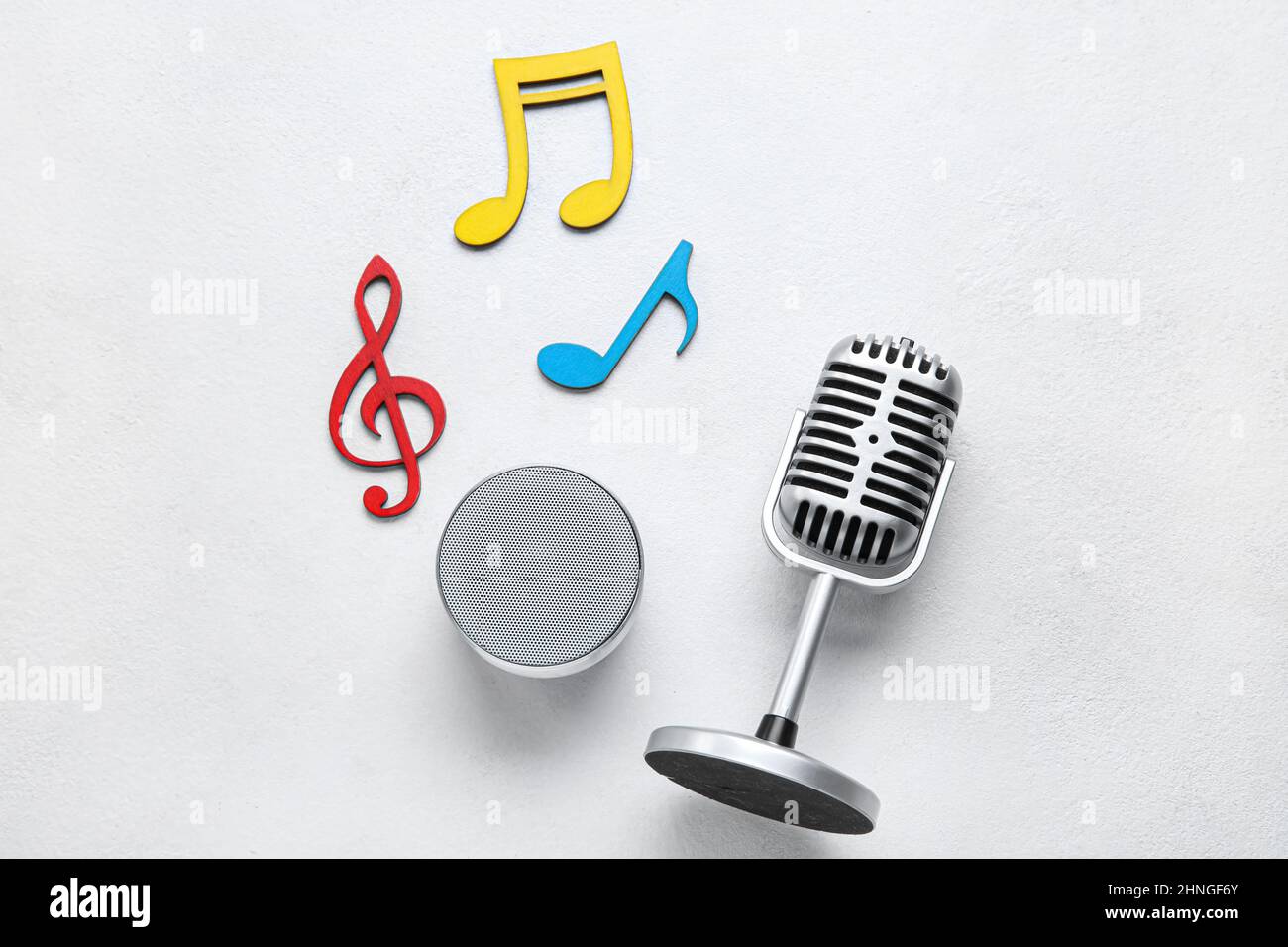 Wireless portable speaker, microphone and music notes on light ...