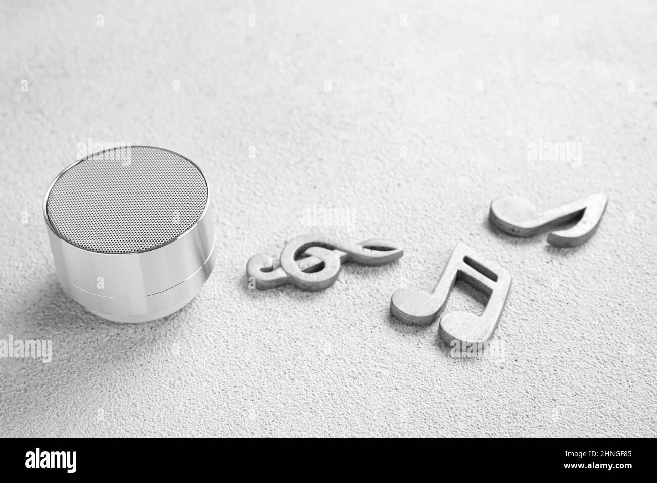 Modern wireless portable speaker and music notes on light background ...