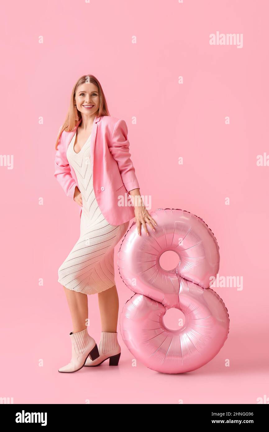 Beautiful woman with big balloon in shape of figure 8 on pink ...