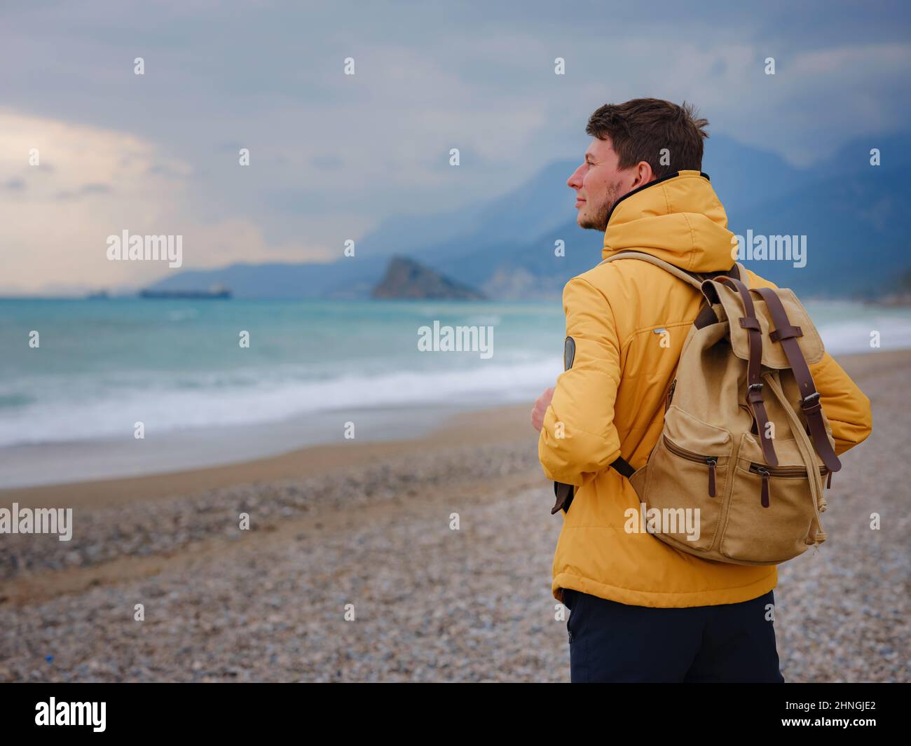 Handsome man in yellow jacket walking beach in antalya, turkey. Good ...