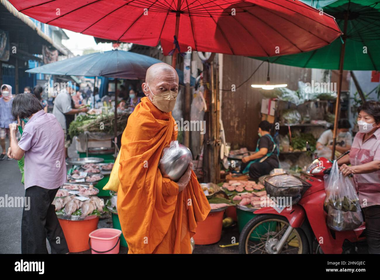 On his customary morning alms round, a Buddhist monk, alms bowl in hand ...