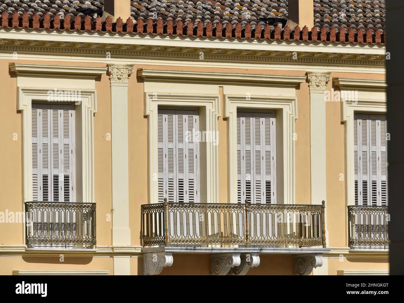 Old Neoclassical house facade with light grey wooden window shutters, a ...