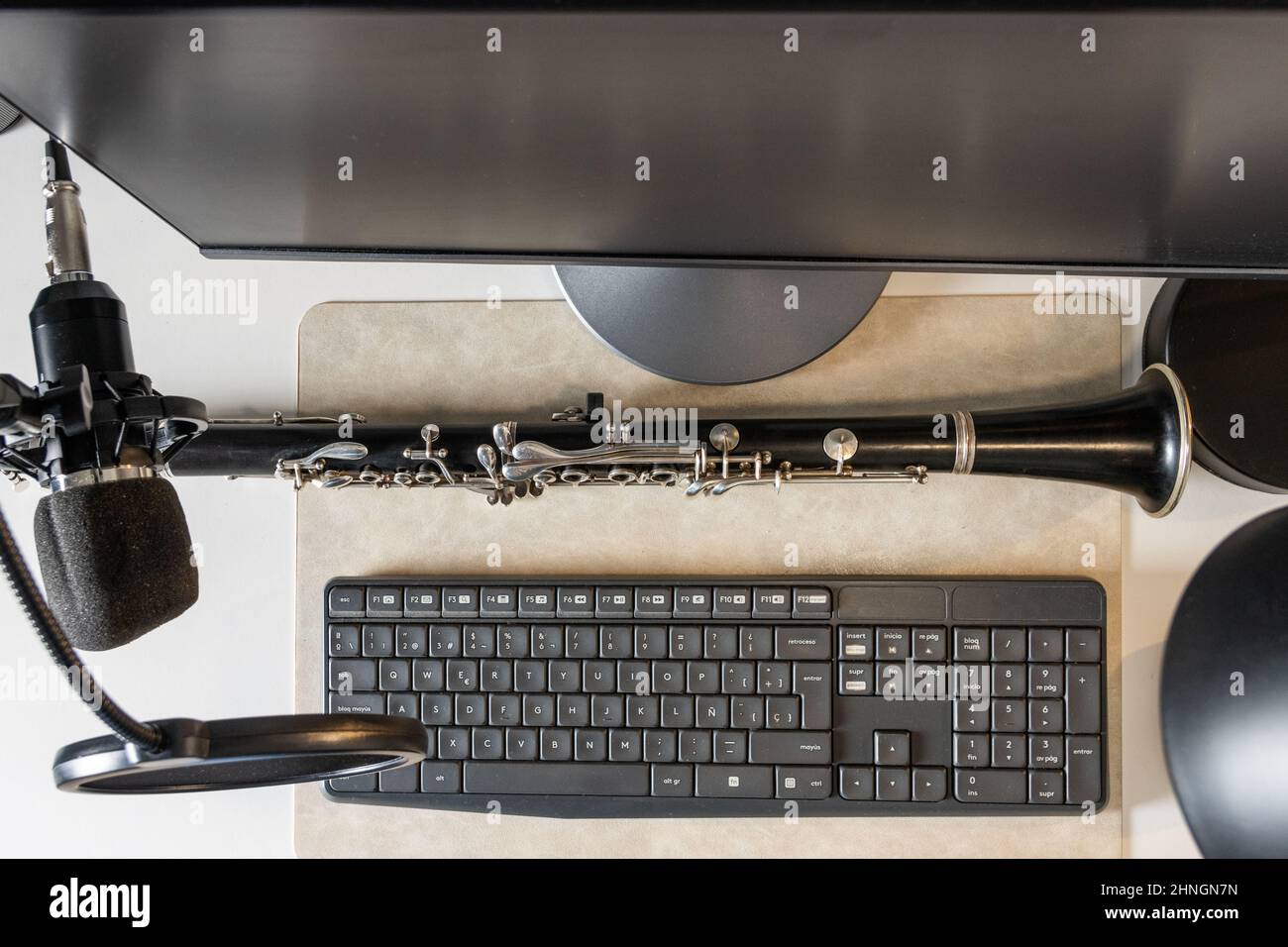 Young entrepreneur playing the clarinet at home and recording music to ...