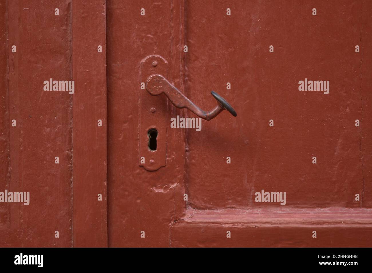 Old traditional rural house ruby red metal door with keyhole and a ...