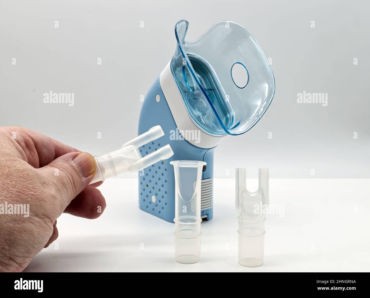 Portable compressor nebulizer on white table. Medical equipment for ...