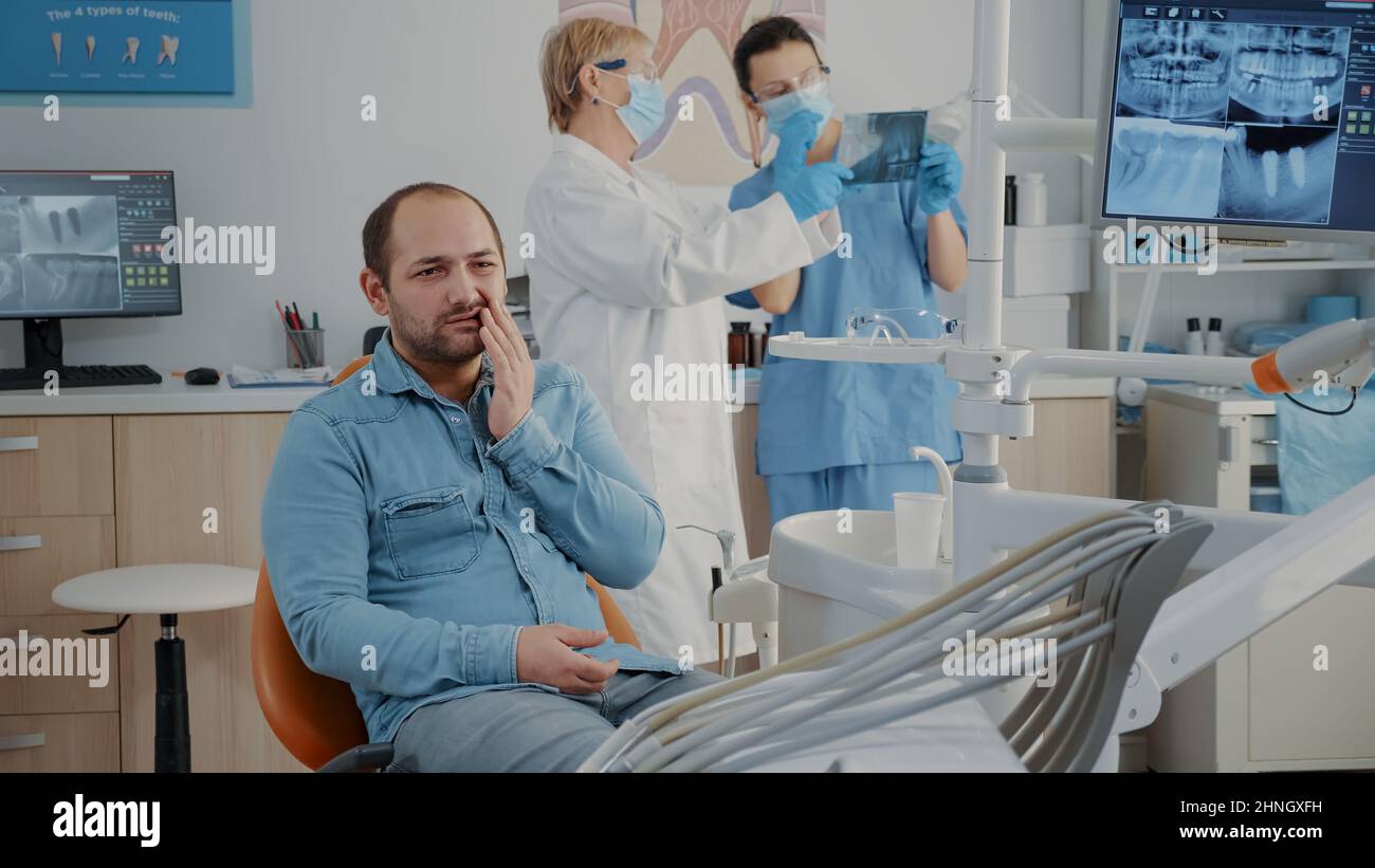 Dentistry patient expressing serious toothache in oral care cabinet ...