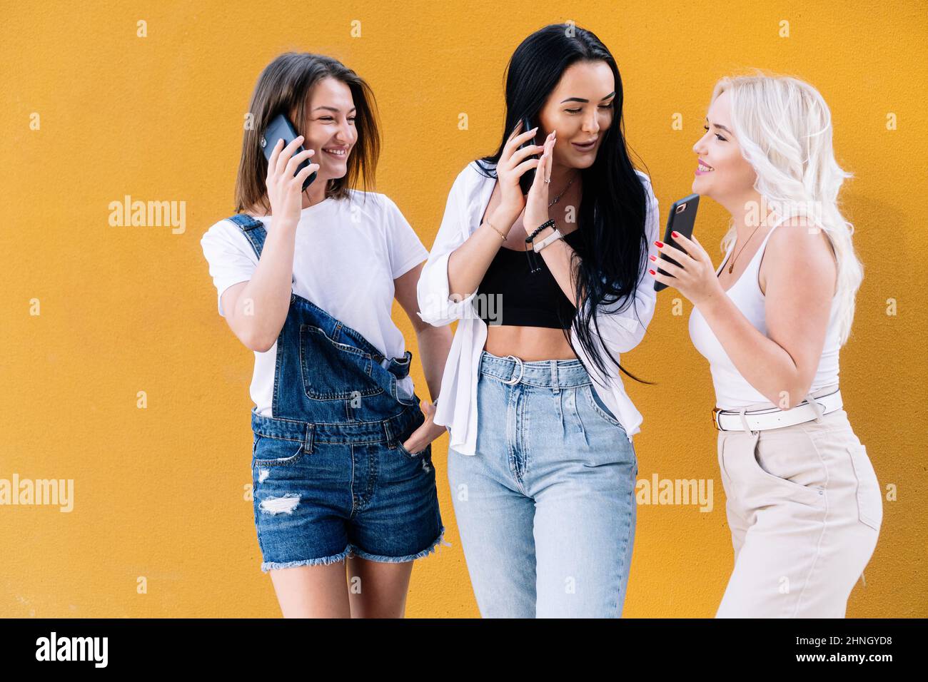 Female friends using mobile phones hi-res stock photography and images ...