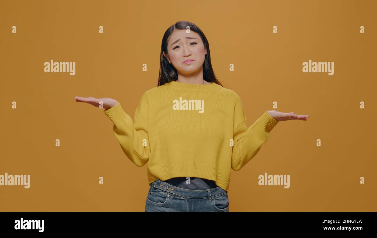 Portrait of confused woman in doubt not knowing answer, standing over ...