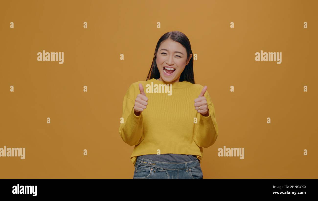 Cheerful person doing thumbs up gesture in front of camera showing ...