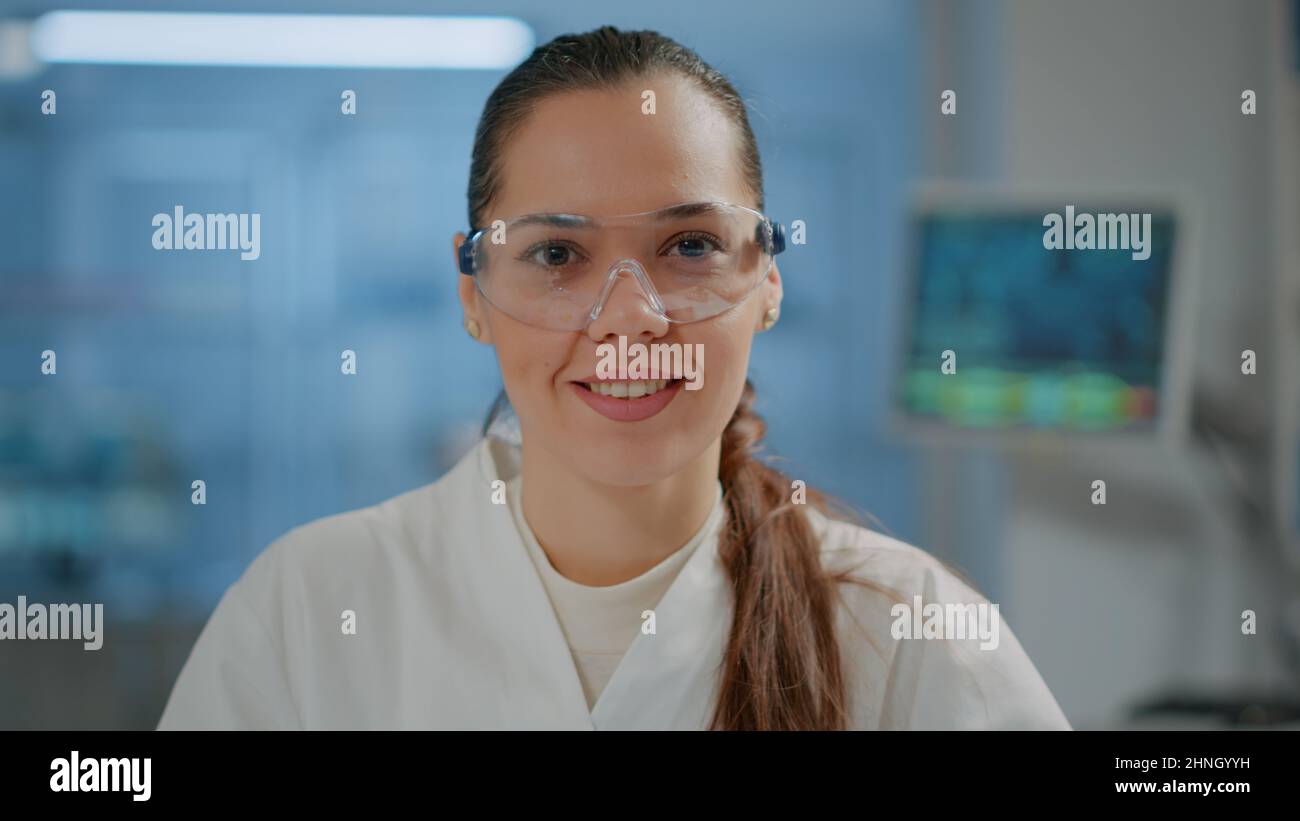 Portrait of woman scientist with goggles smiling in laboratory, getting ...