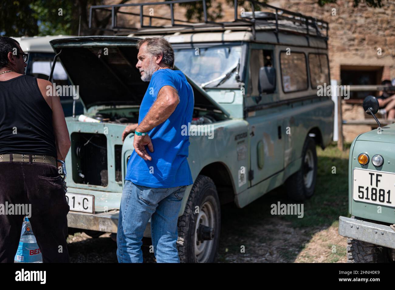 Mr. owner of a classic Land Rover repairing the engine and talking ...