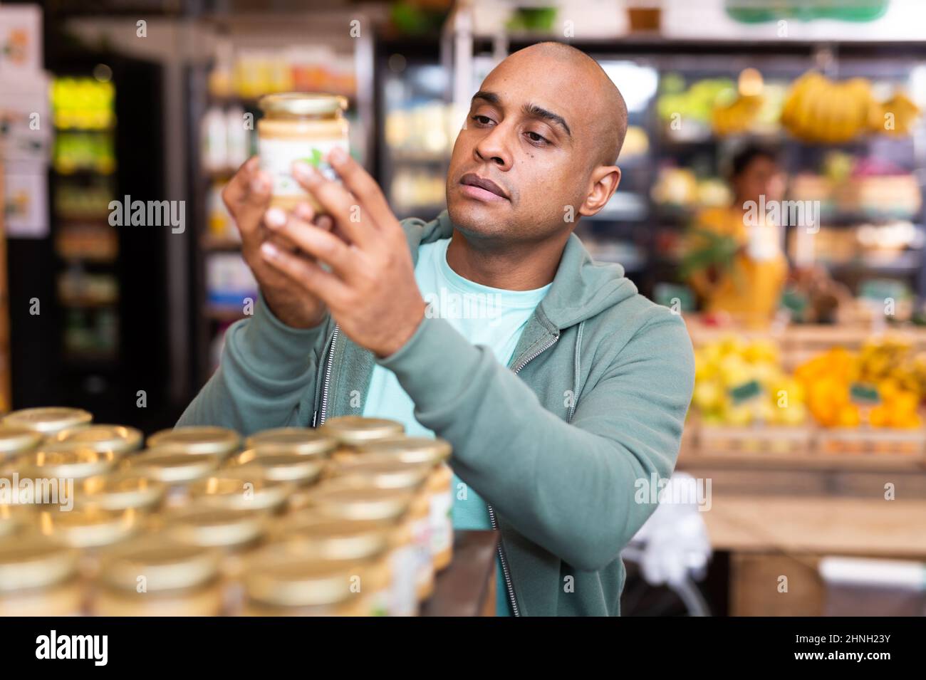 Man reading jar contents on label while shopping in supermarket Stock ...