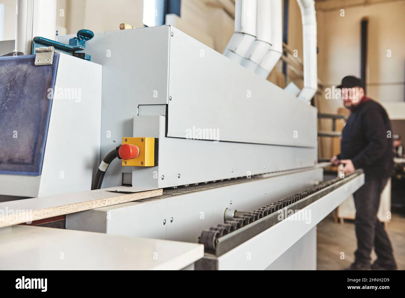 Sawing up of a wooden board on a sliding table saw. Woodworking and ...