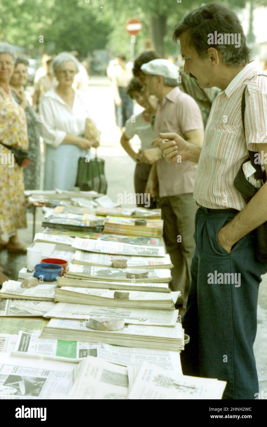 Bucharest, Romania, 1990. People looking to buy newspapers from a ...
