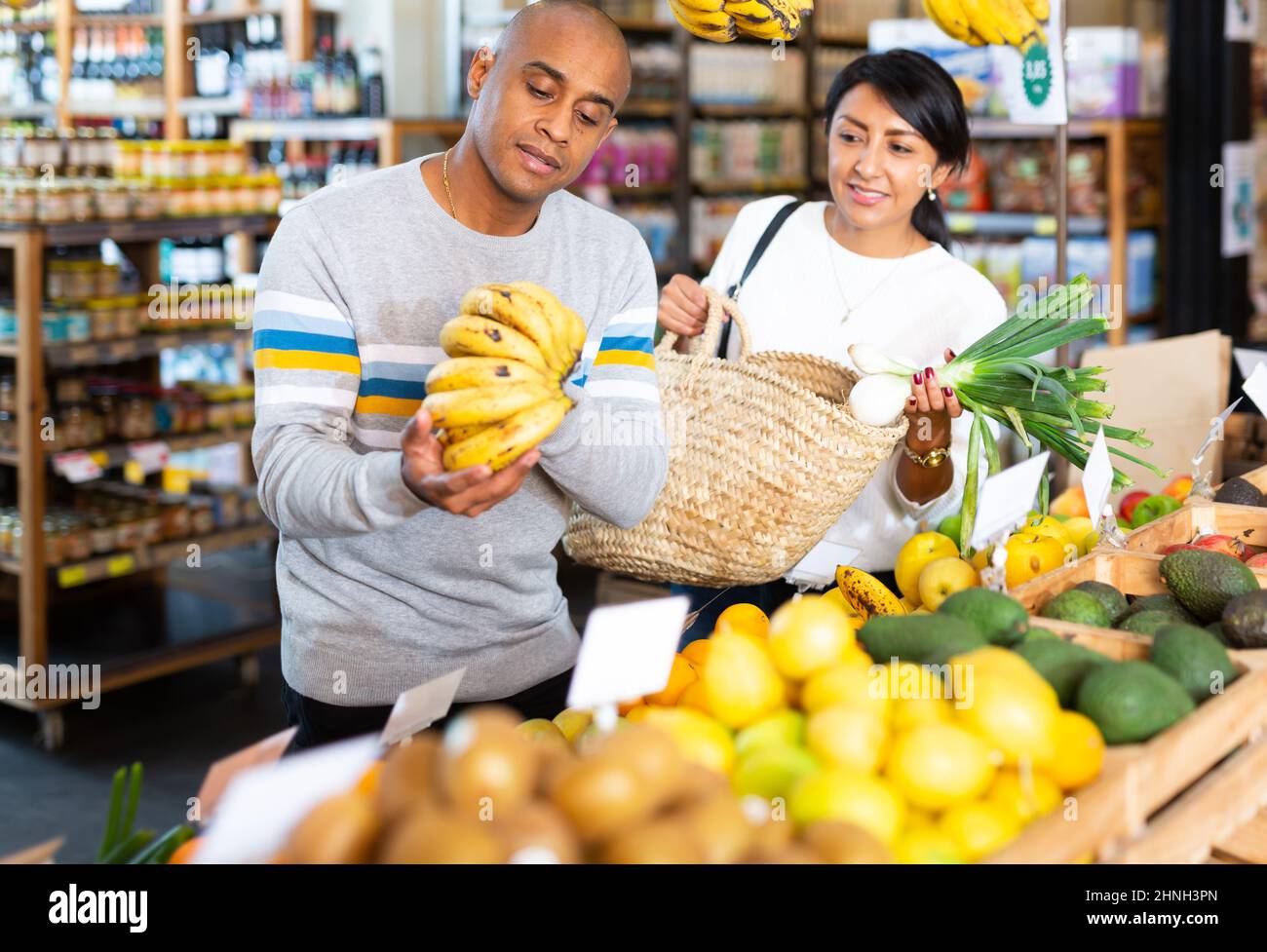 Hispanic couple choosing vegetables and fruits in grocery store Stock ...