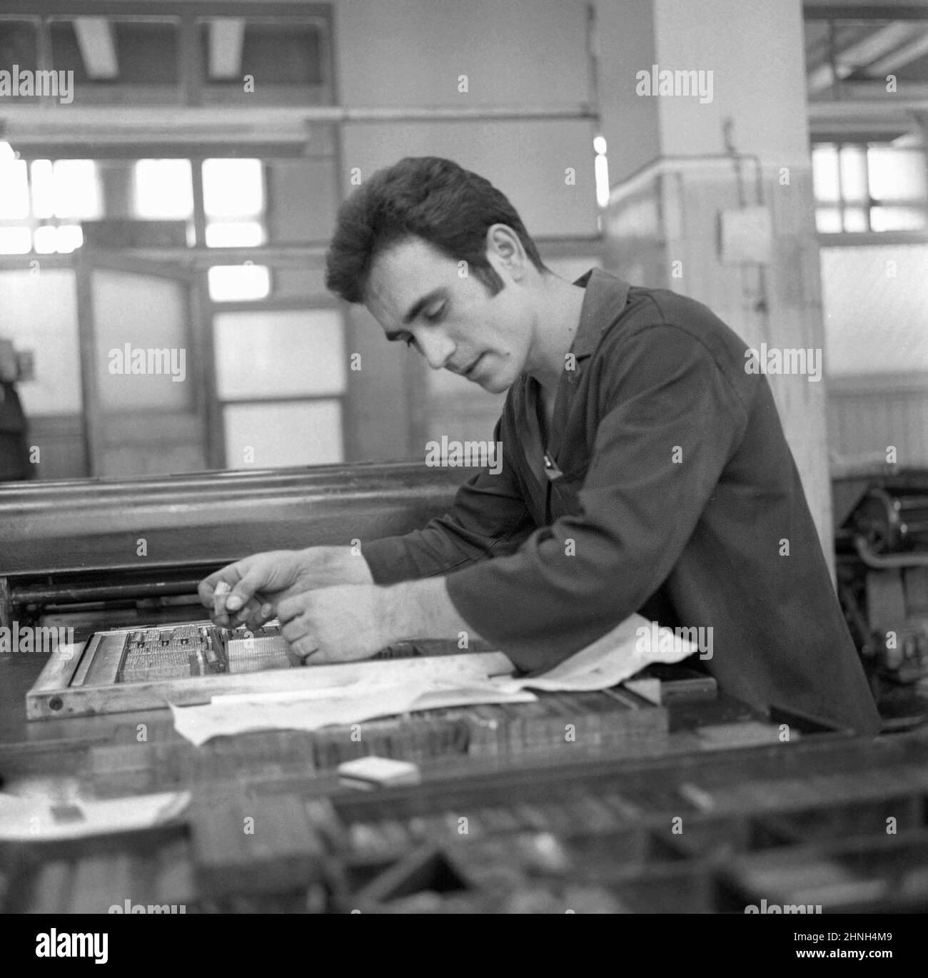Printing press in Romania in the1970s. Worker manually placing the lead ...