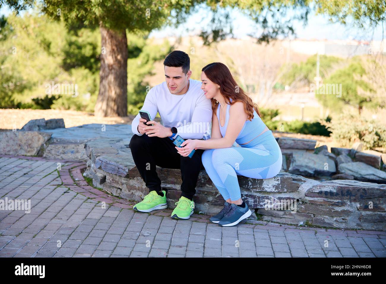 Shot of Caucasian models man and woman sitting together in the park and ...