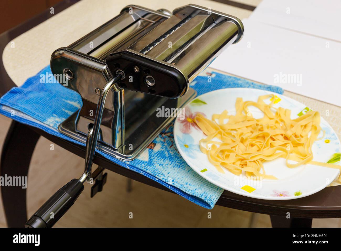 Making noodles with pasta machine in home Stock Photo - Alamy