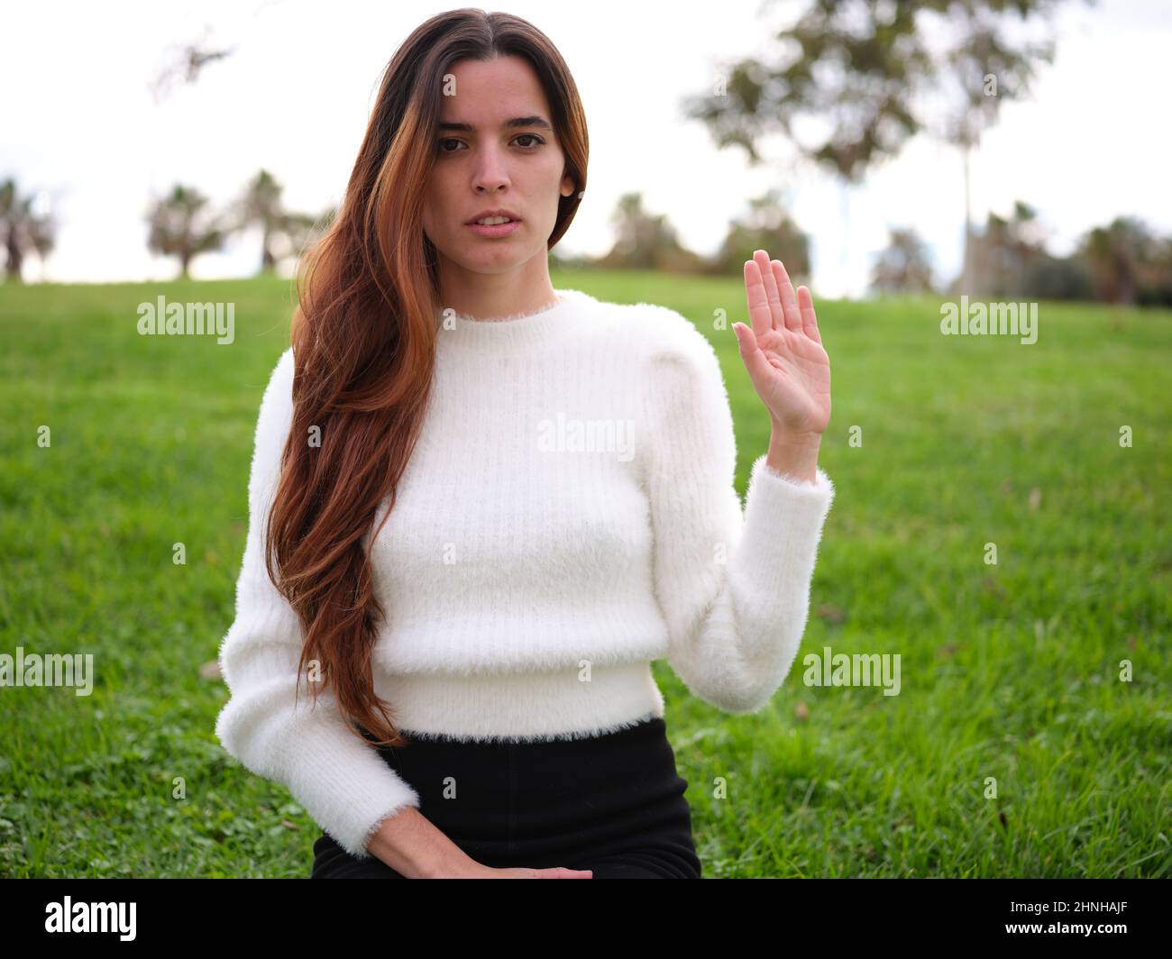 I swear. Portrait of a sincere young girl raising a hand to oath Stock ...